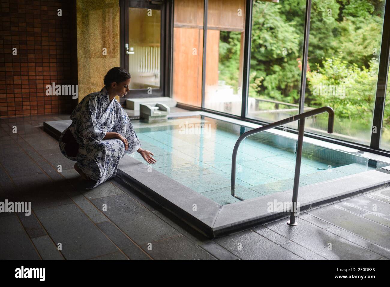 Young caucasian Woman in a kimono touching thermal waters before ...