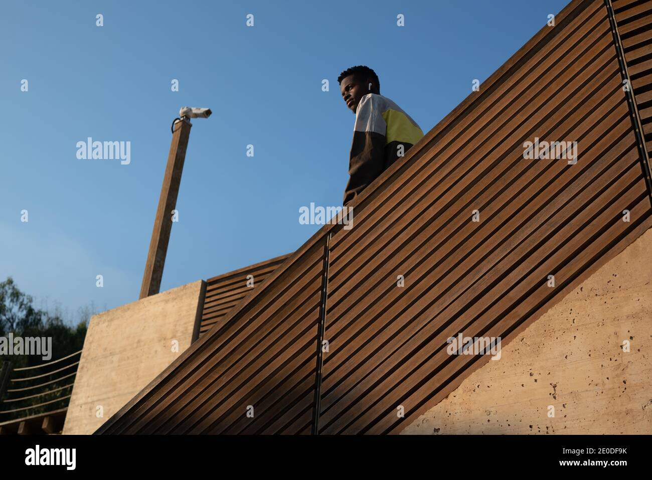 Back view of female tourist standing on rock near Tiemu Falls in forest ...