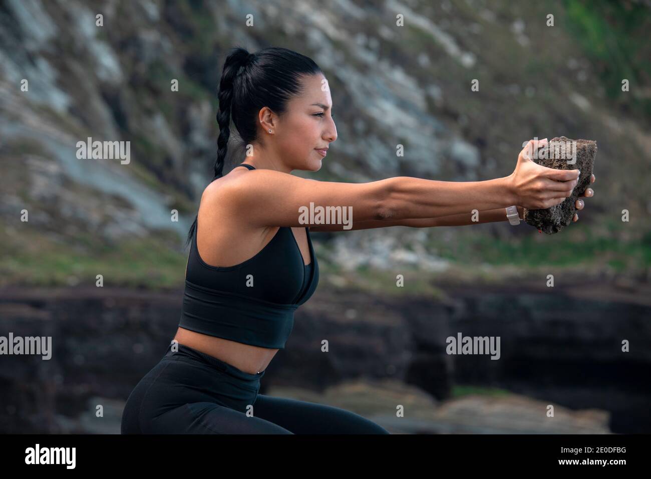 Side view of glad female athlete in sportswear doing squat exercise ...