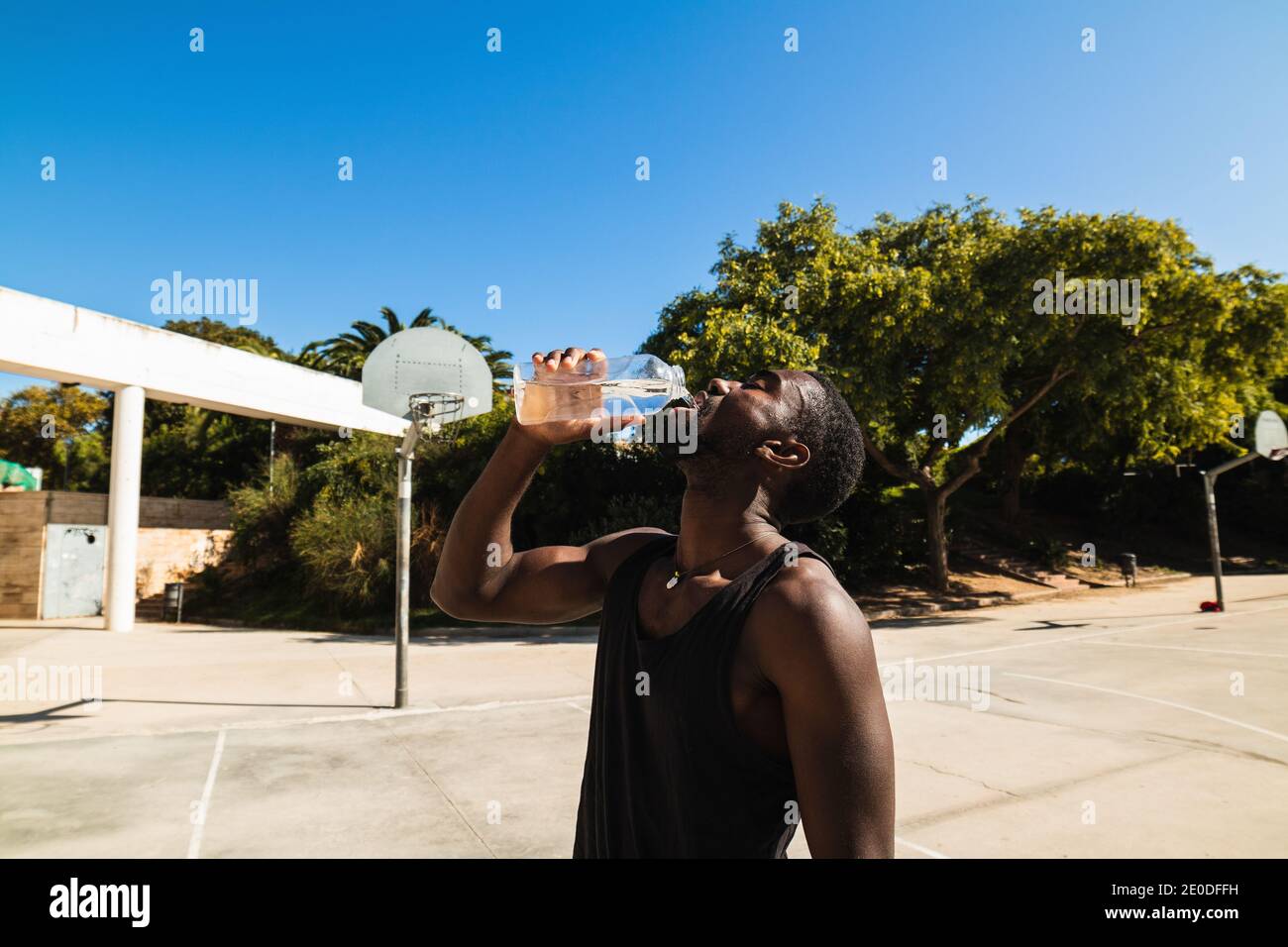 Thirsty African American male basketball player standing on sports ...