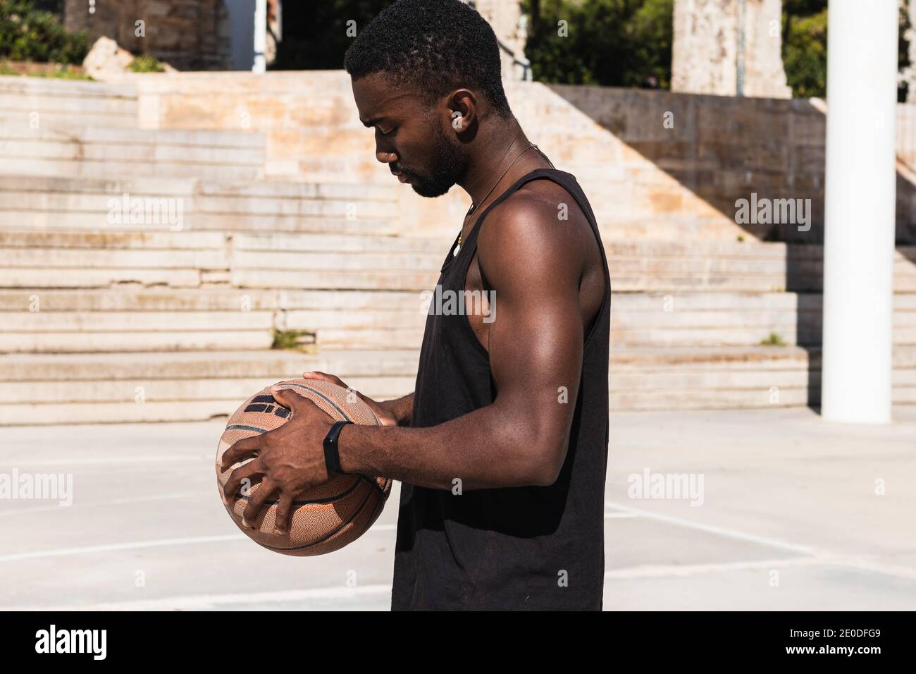 Side view of fit African American male standing on basketball court ...