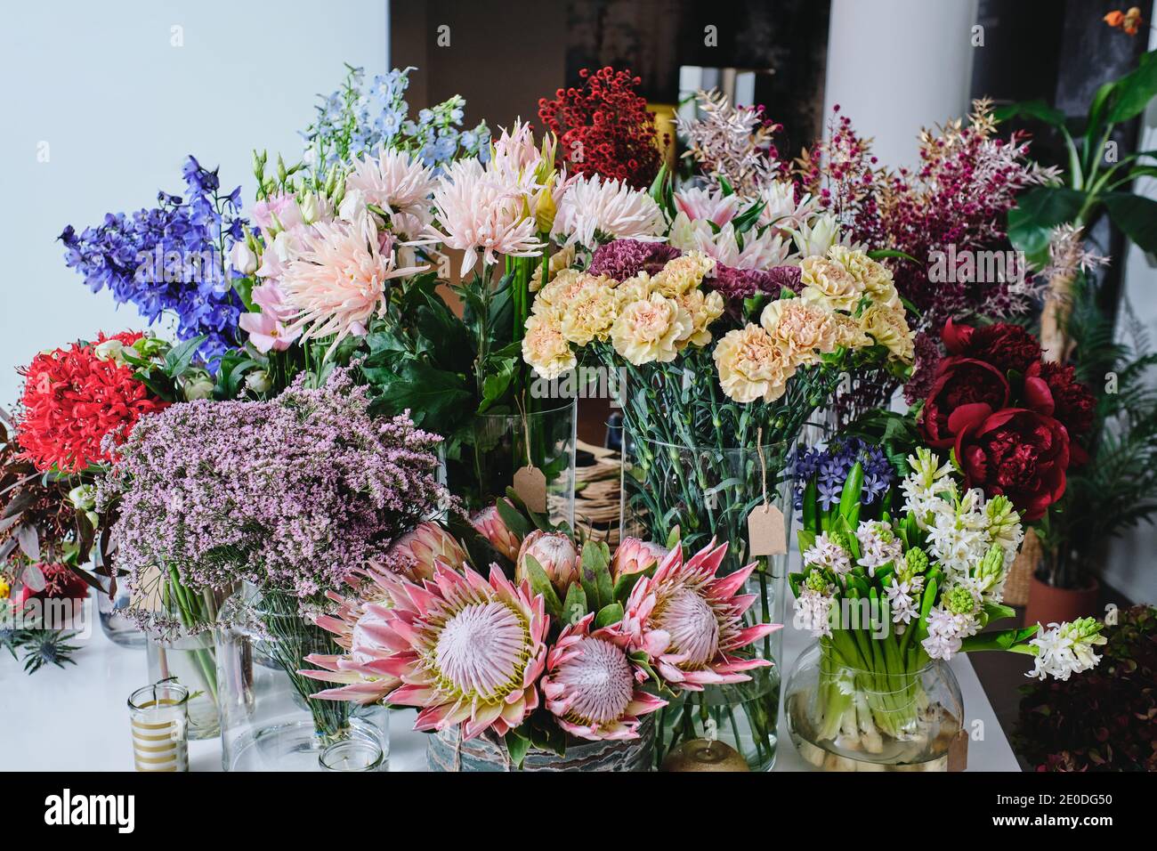 Colorful assorted flowers and plants in baskets and vases placed in ...