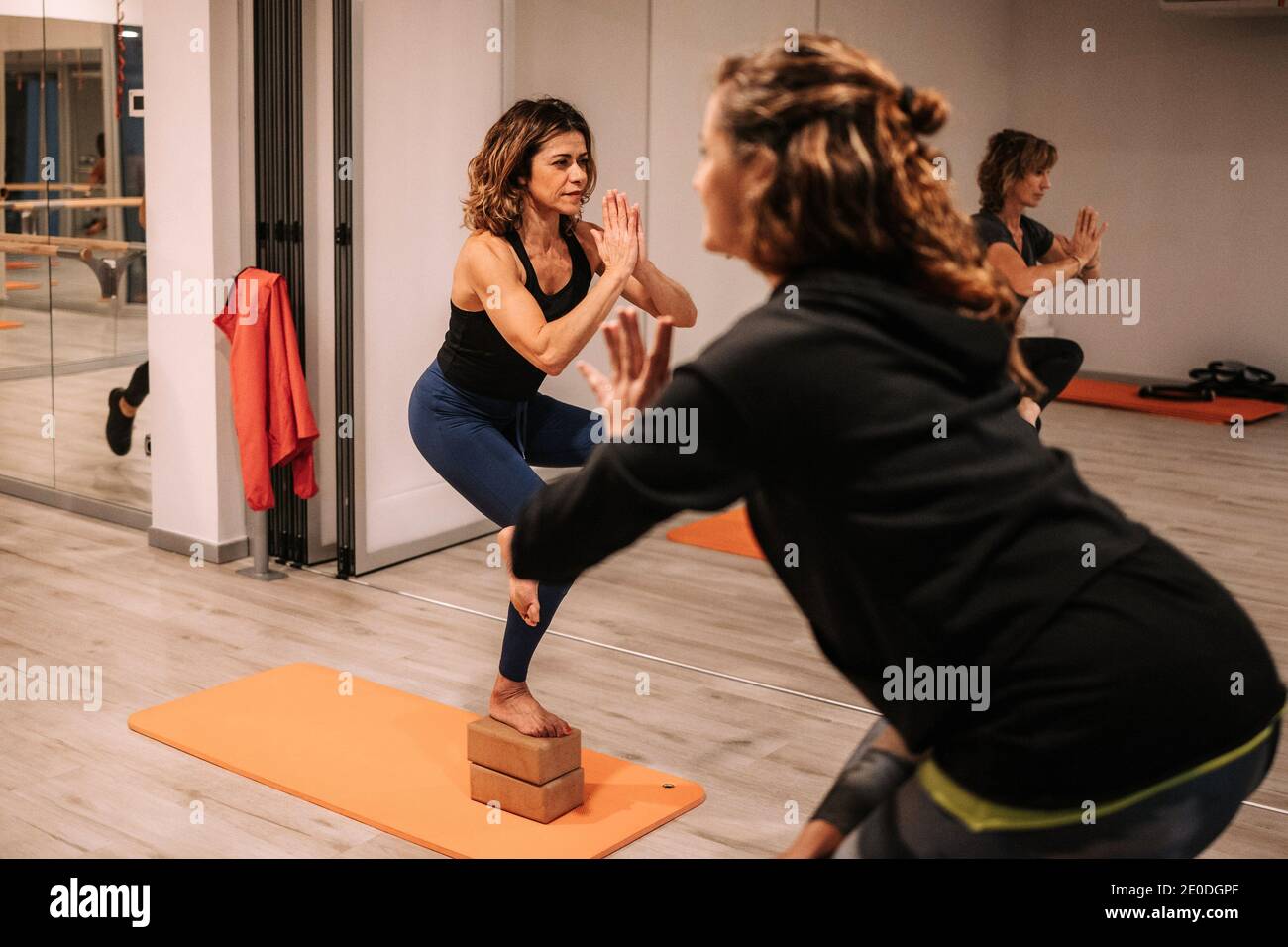 Women in activewear standing in Figure Four pose on bricks and ...