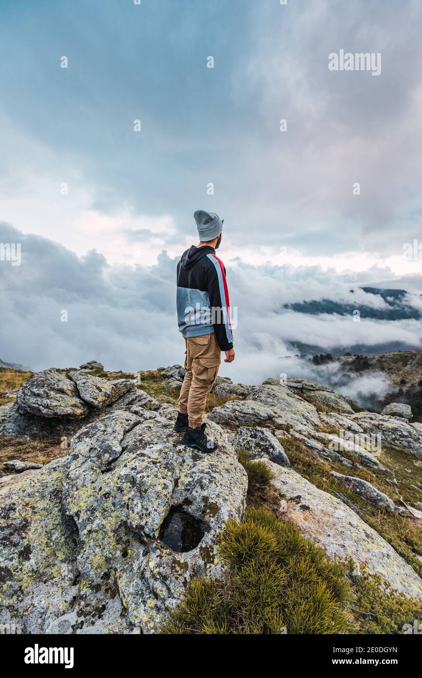 Back view of male hiker standing on top of hill and enjoying freedom in ...
