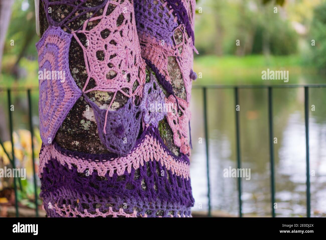 Colorful crochet textiles around a tree on a forest park Stock Photo ...