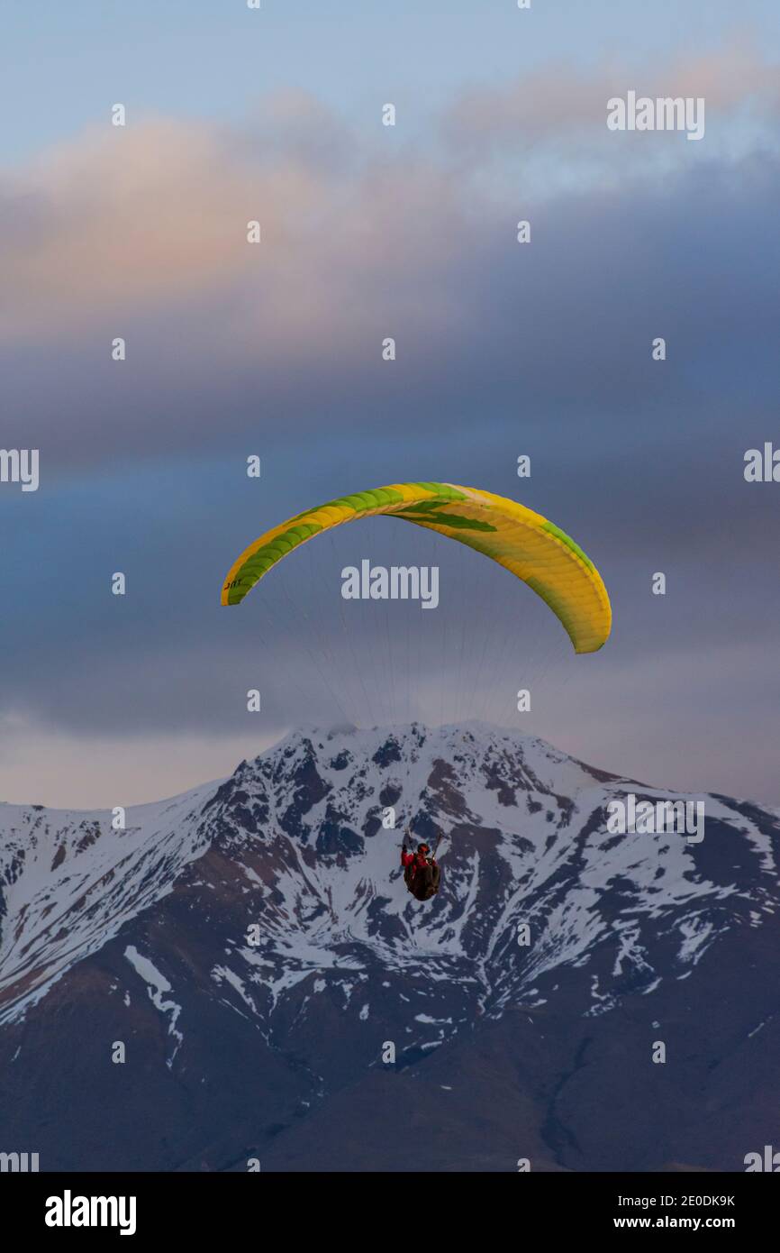 Paragliding against snow-capped Andes mountains during winter season in ...