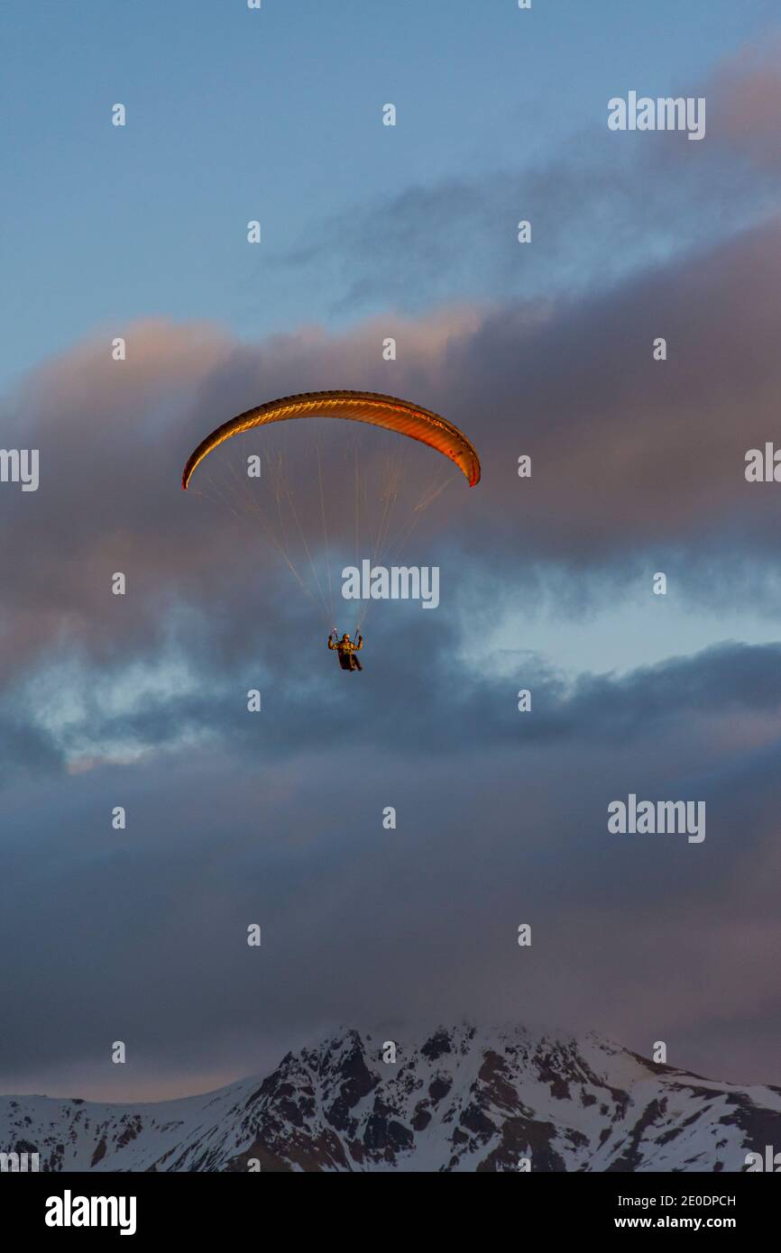 Paragliding against snow-capped Andes mountains during winter season in ...