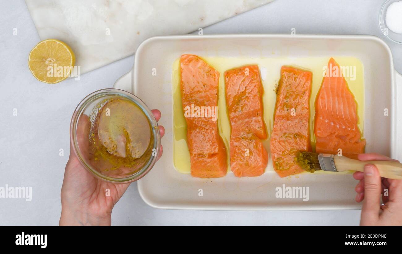 Baked salmon fillet recipe. Chef topping fish slices with marinade ...