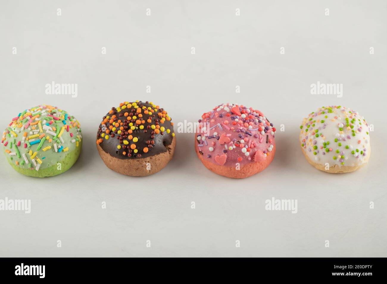 Colorful sweet small doughnuts on a white background Stock Photo - Alamy