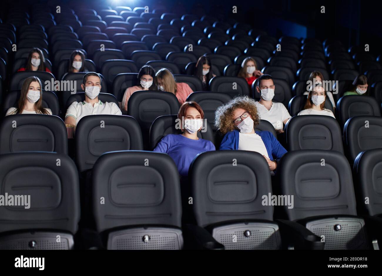 Front view of people enjoying film during world pandemic, looking at ...