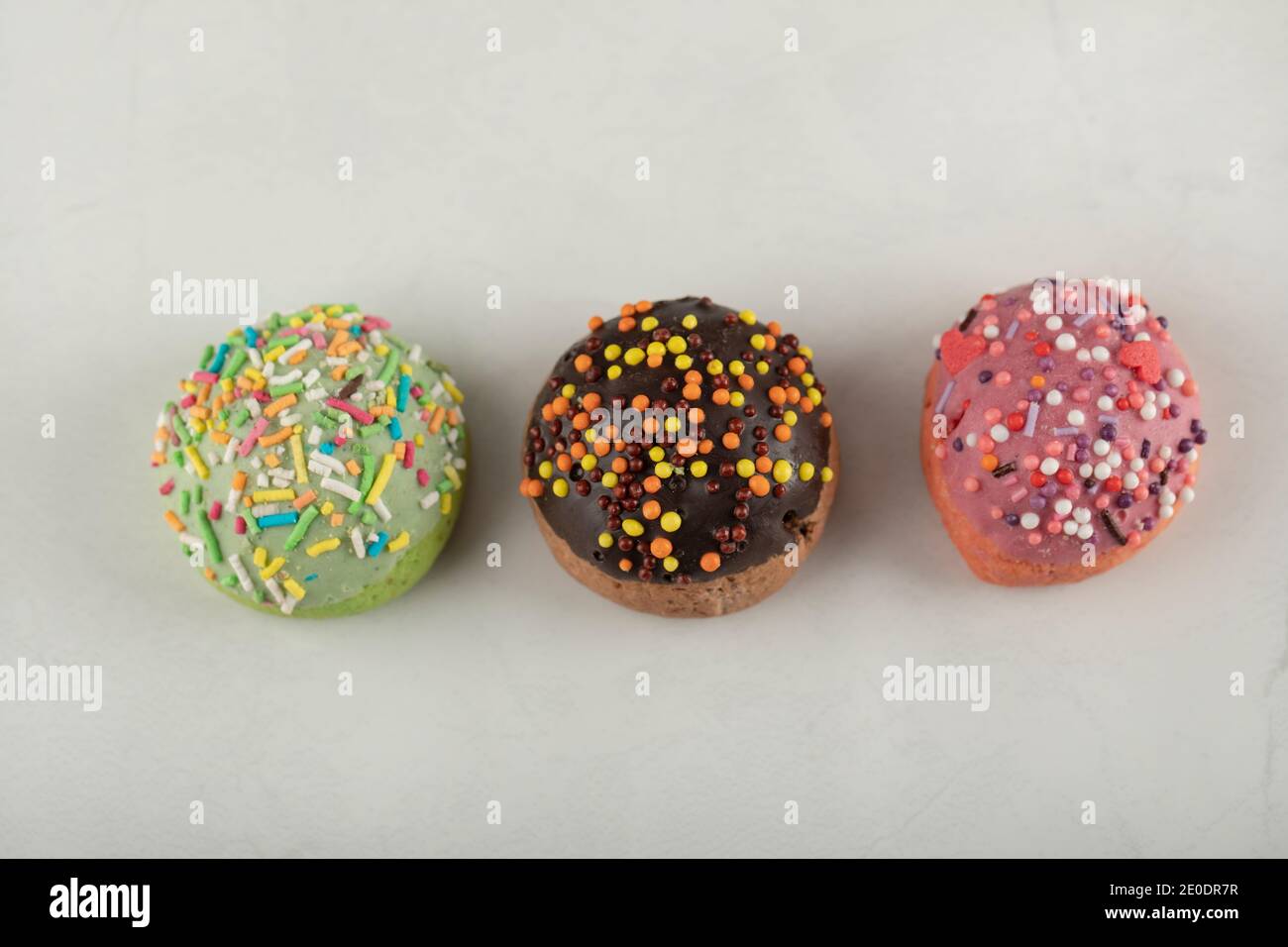 Colorful sweet small doughnuts on a white background Stock Photo - Alamy
