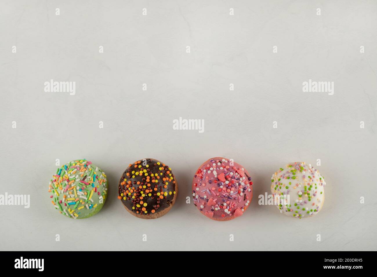 Colorful sweet small doughnuts on a white background Stock Photo - Alamy