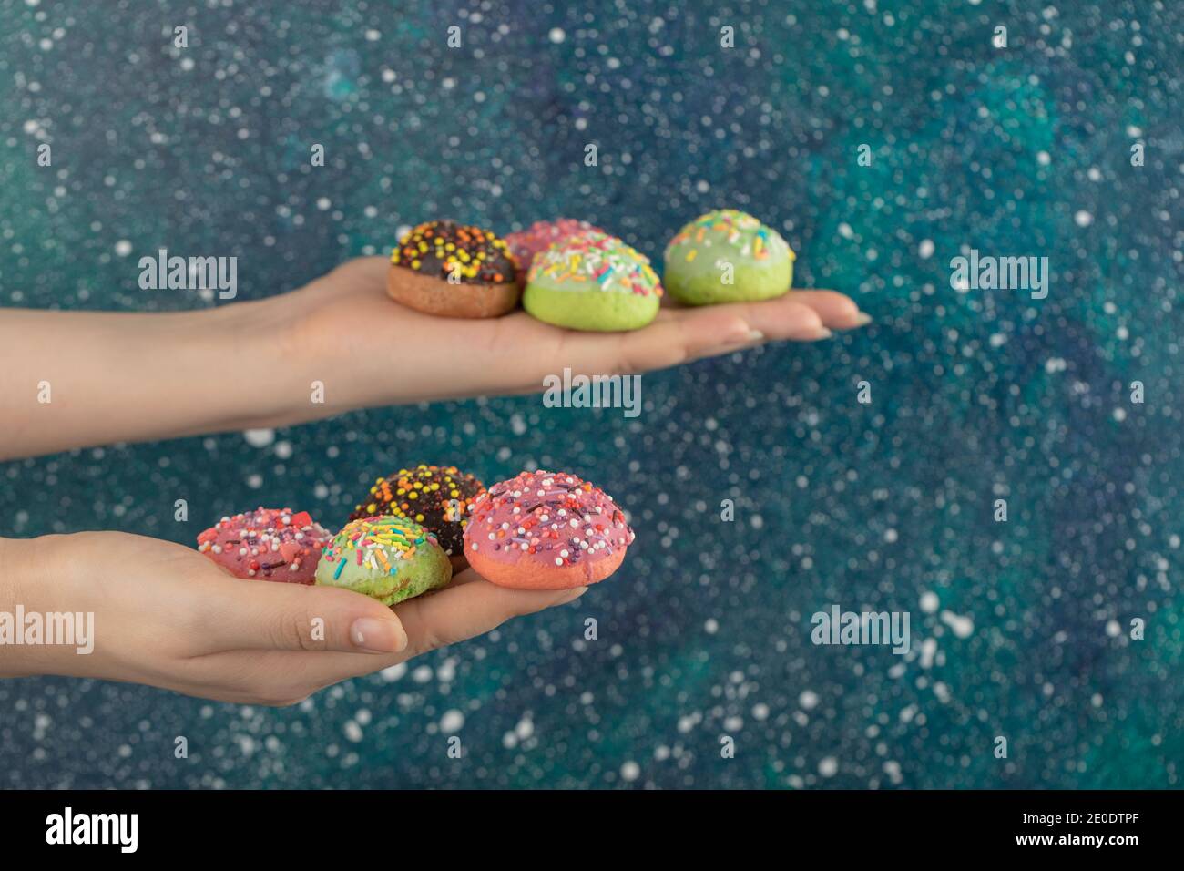 Hands holding colorful sweet small doughnuts with sprinkles Stock Photo ...