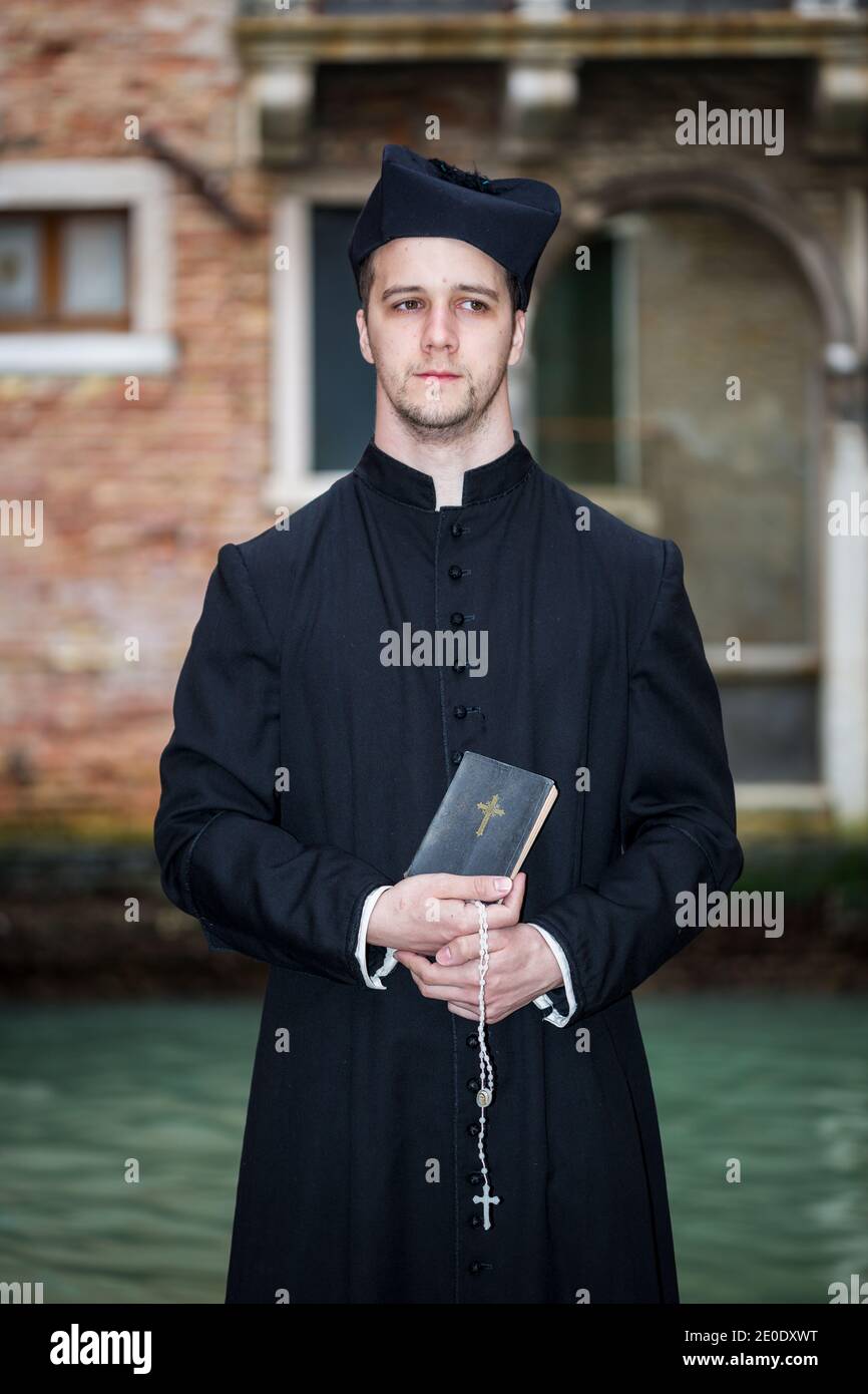 young priest in venice in front of canal Stock Photo - Alamy