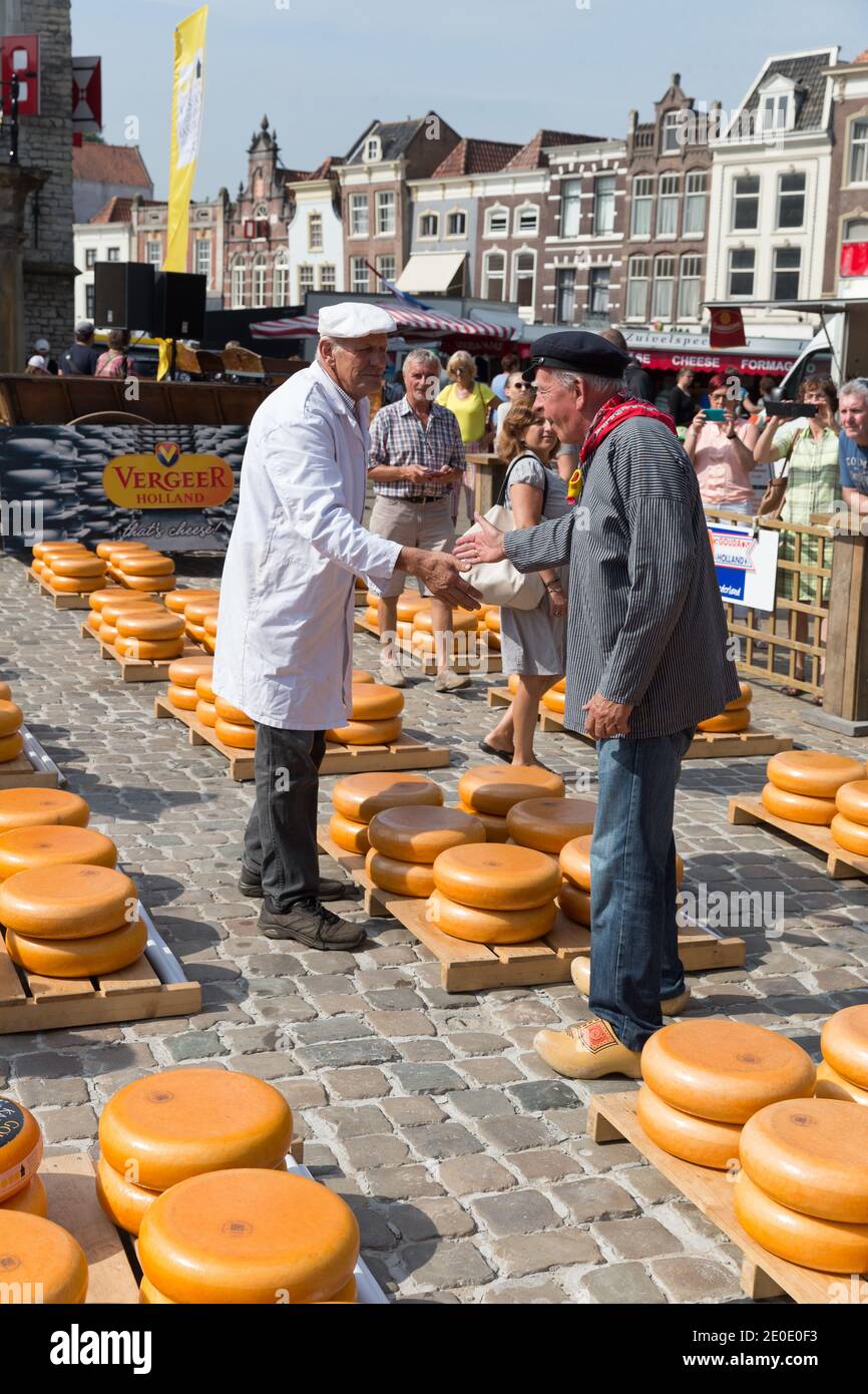 After a negotiation, the cheese trader and farmer close the deal by ...