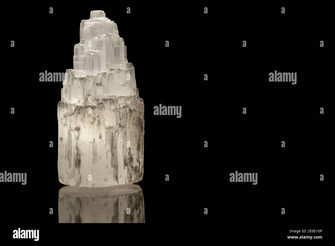 A glowing white fibrous crystal in the dark. The crystal is hovering ...