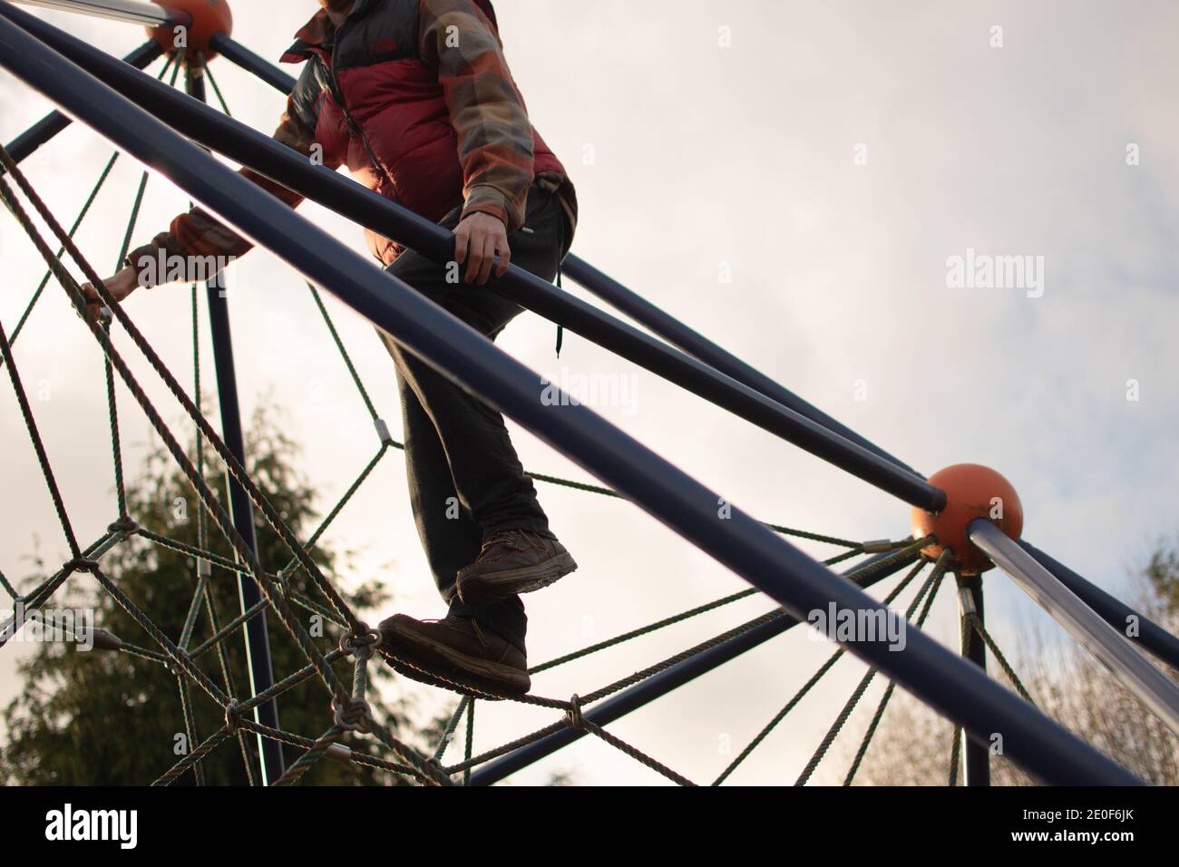 Adult male climbs playground structure Stock Photo - Alamy