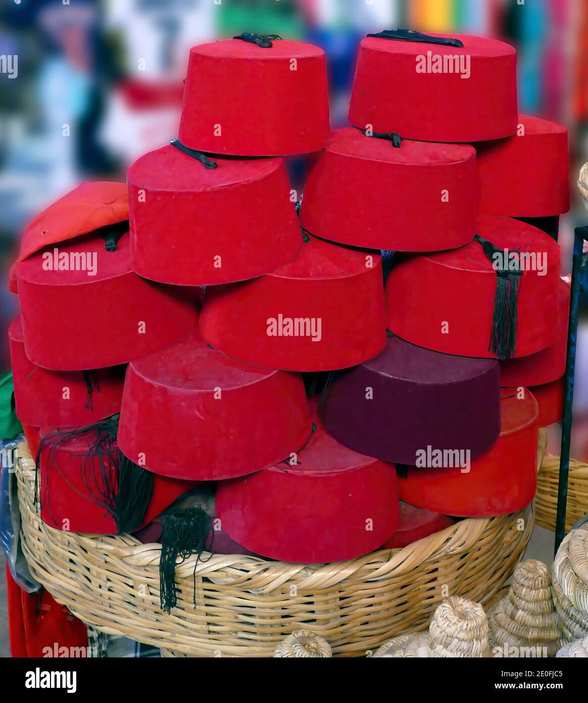 Red Fez tarbouche and white wicker tagine cookers, market medina of ...