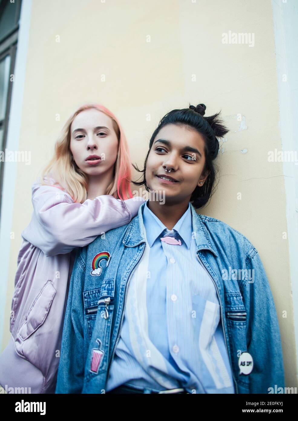 Two teenage girls infront of university building smiling, having fun ...