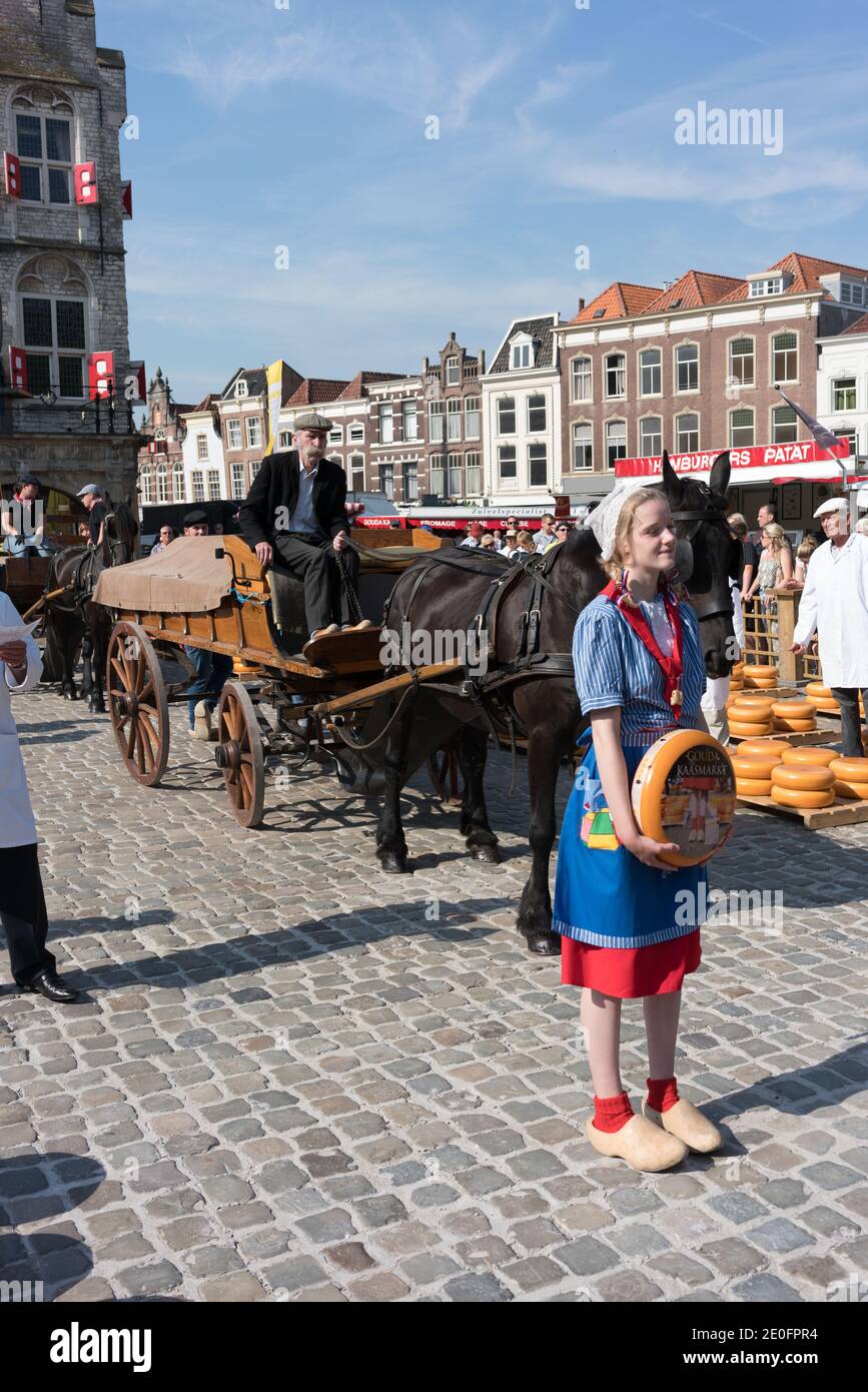 Girl in traditional dutch costume poses for tourists with a wheel of ...