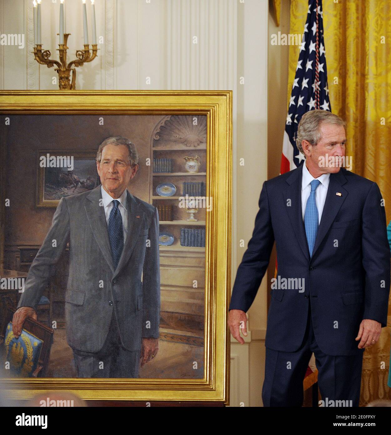 Former President George W. Bush poses next to his portrait during the ...