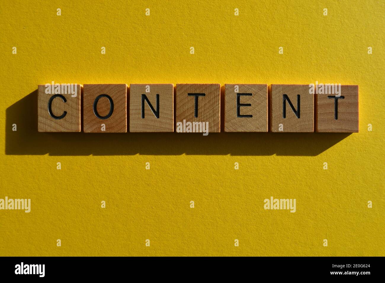 Content, word in wooden alphabet letters isolated on bright yeloow ...