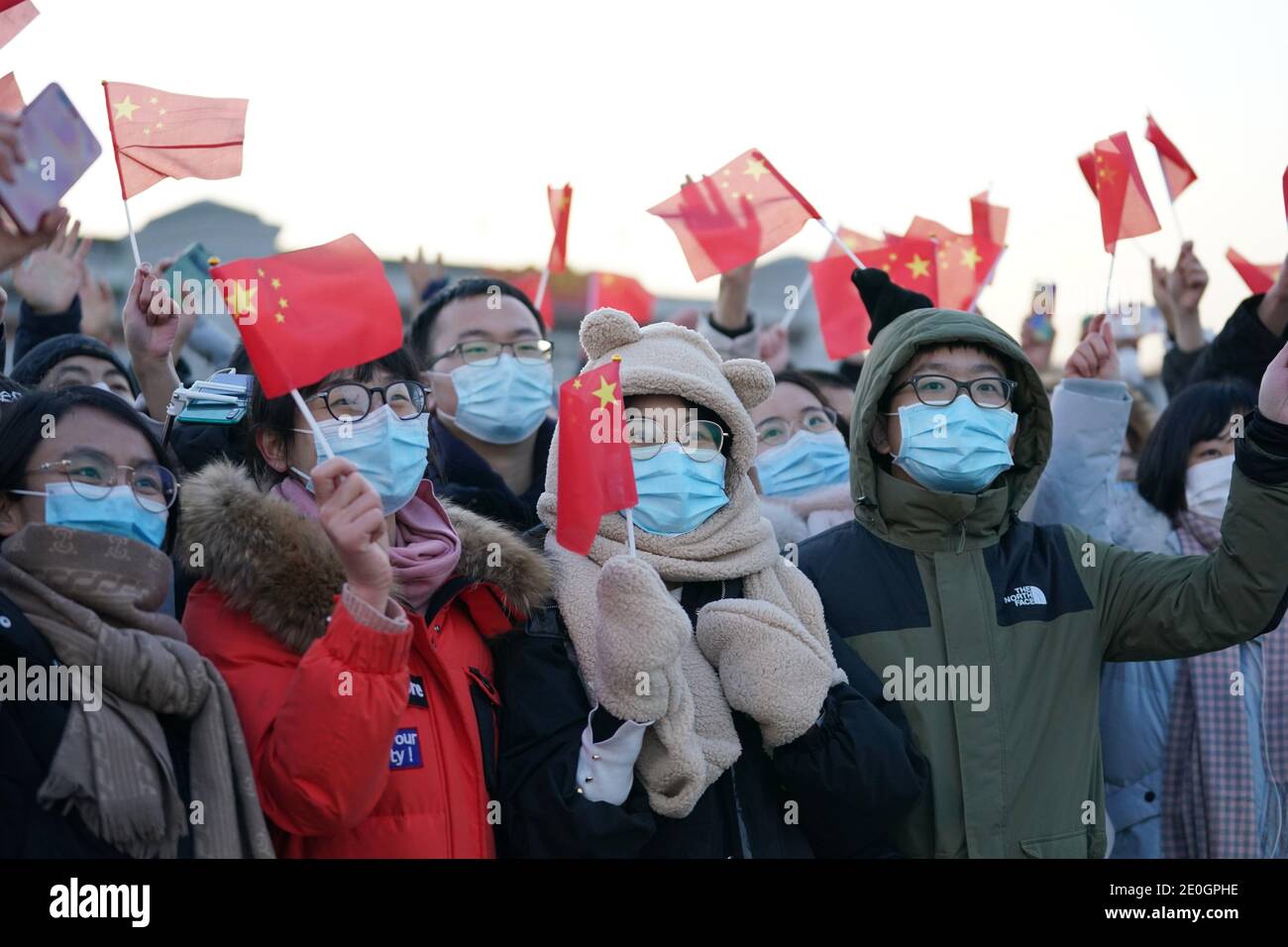 Beijing, China. 1st Jan, 2021. People wave Chinese national flags after ...