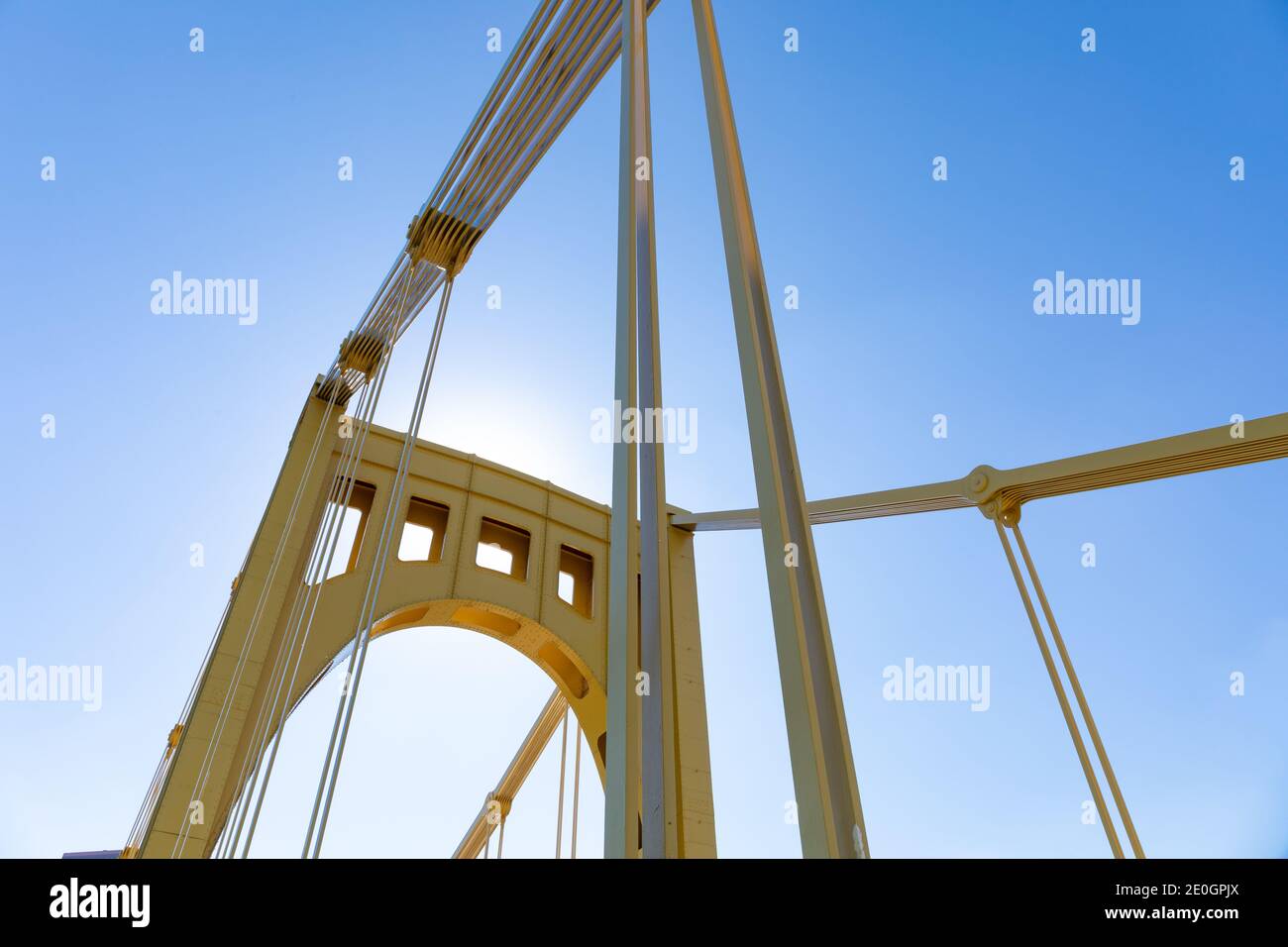 Sun behind the upright support of a self anchored suspension bridge ...