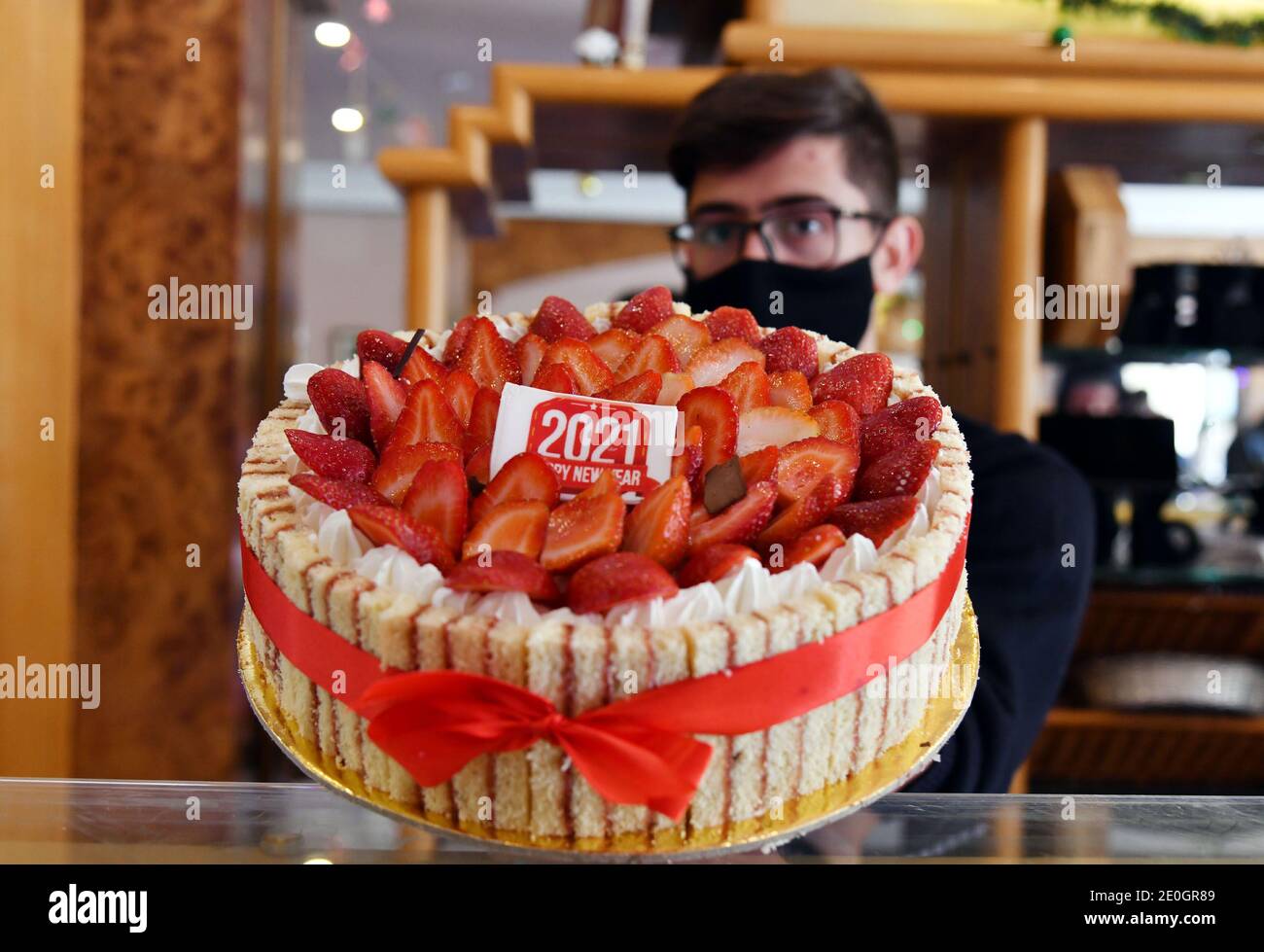 Damascus. 31st Dec, 2020. A pastry maker shows a cake to greet the New ...