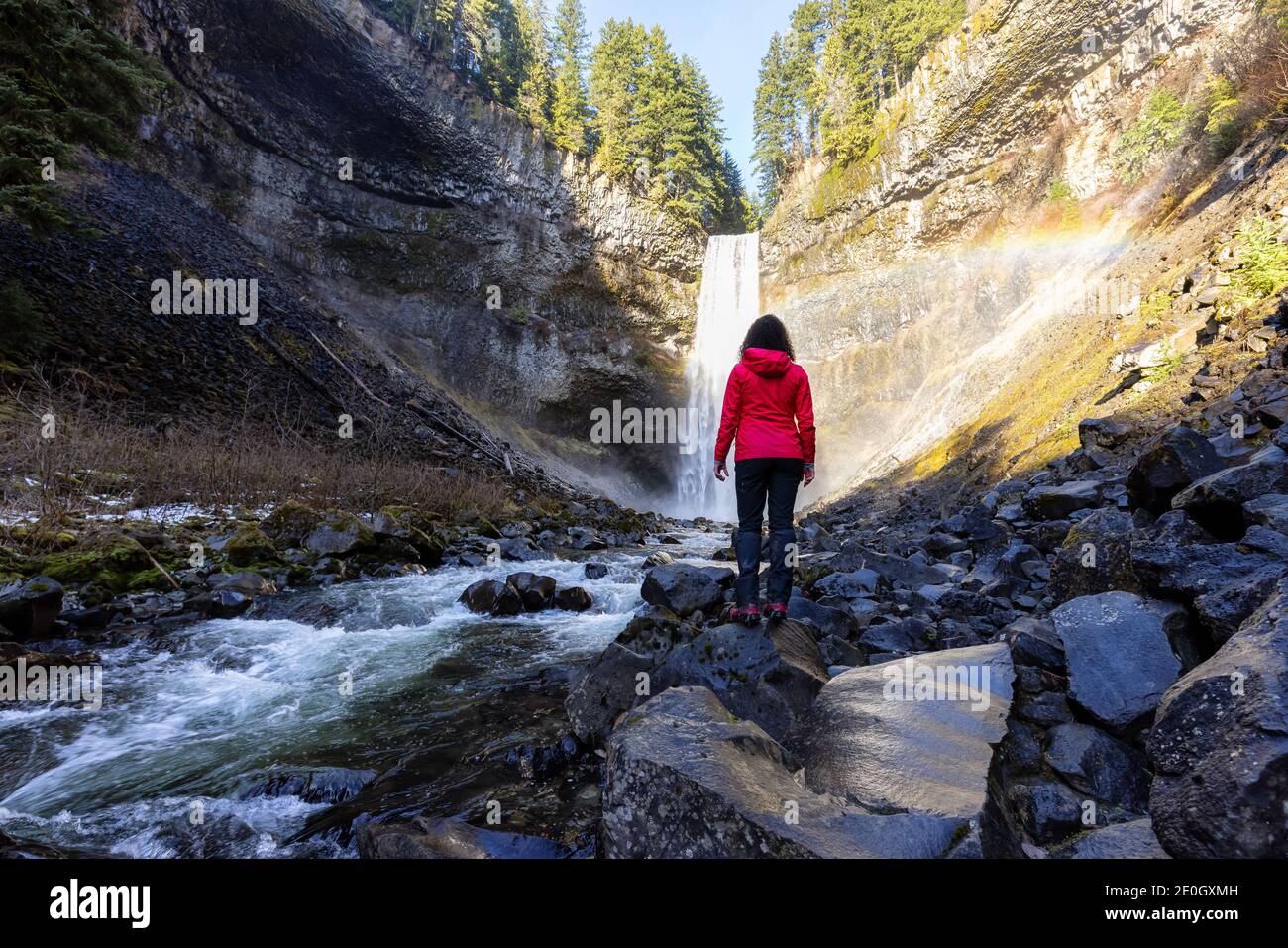 Girl watching a beautiful waterfall in Canadian Nature Stock Photo - Alamy
