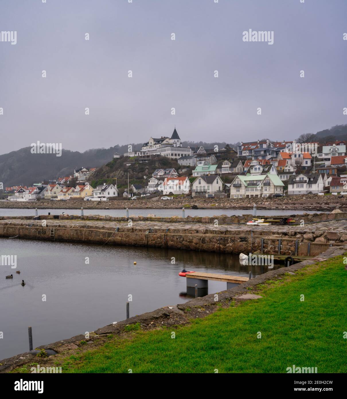 An empty marina in the winter. Mountains in fog in the background ...