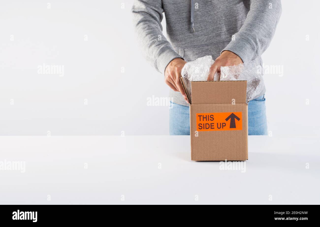 packing a box on top of a white table Stock Photo - Alamy