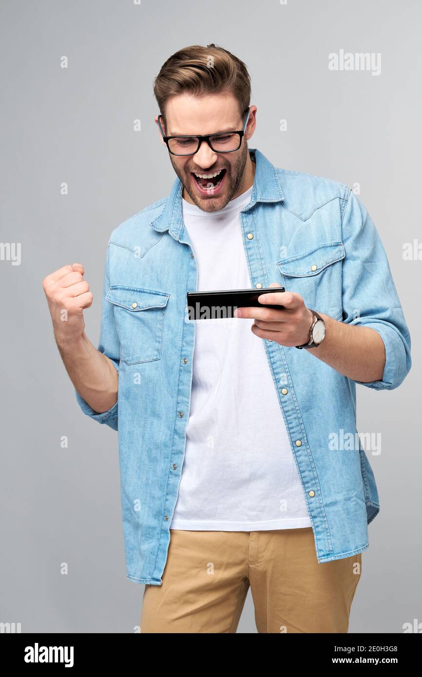 pretty casual man in blue jeans shirt holding his phone standing over ...