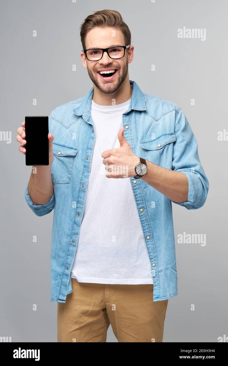 pretty casual man in blue jeans shirt holding his phone standing over ...