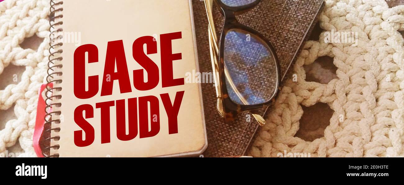 Case study memo written on a notebook with pen, glasses on crochet ...
