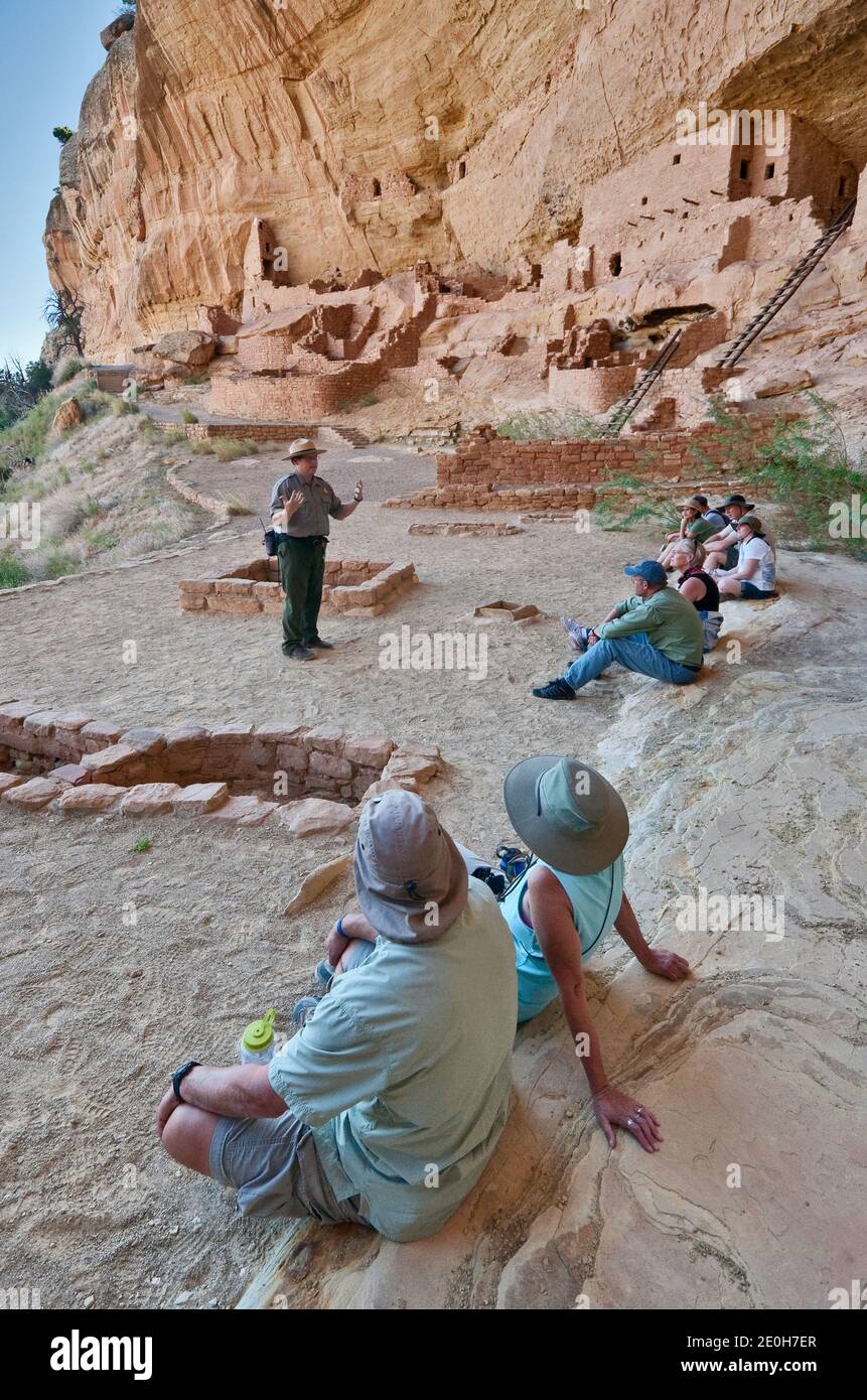 Park guide and visitors at Long House cliff dwelling in alcove at ...