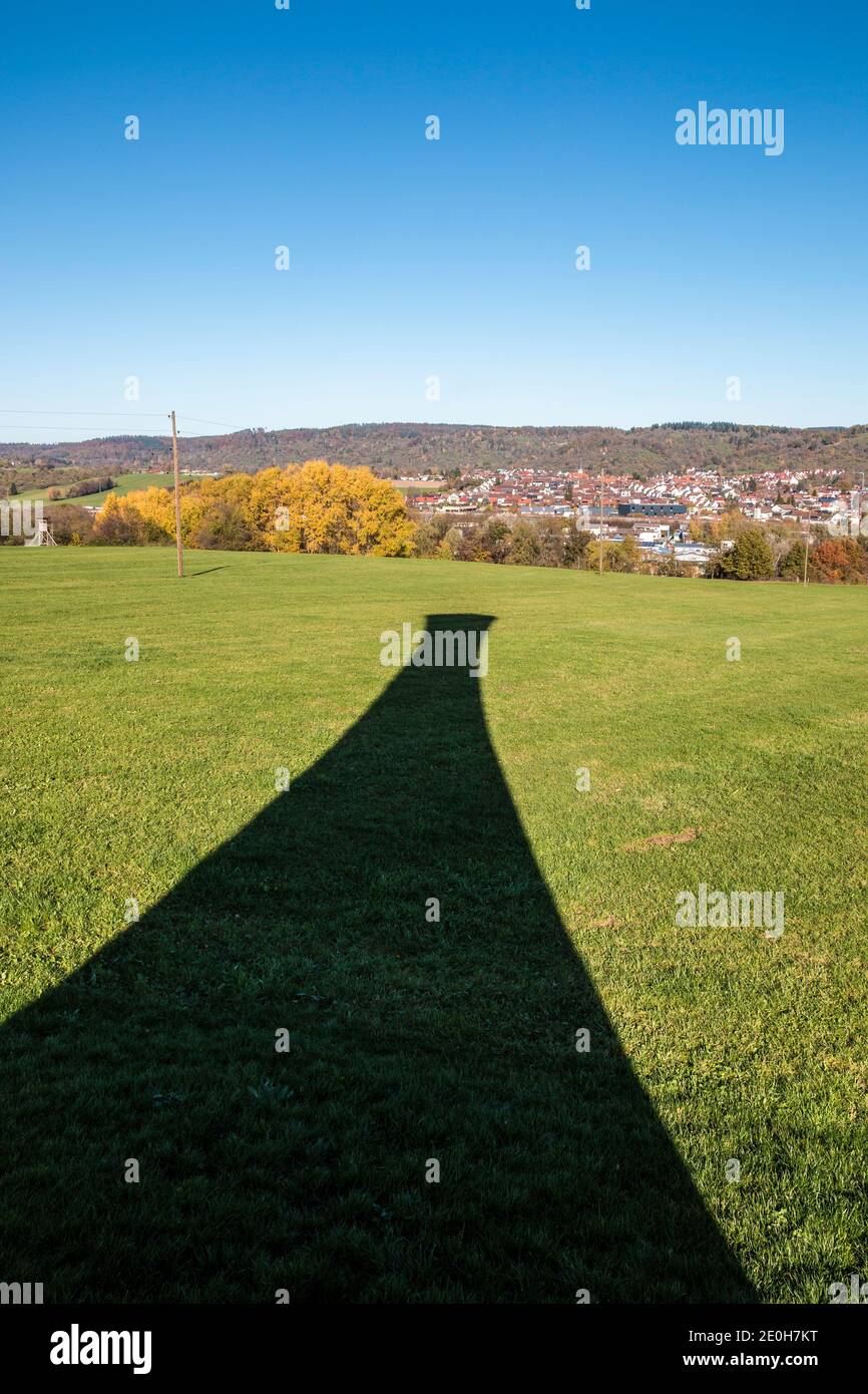 Black shadow of a tower on the green field near the town Stock Photo ...