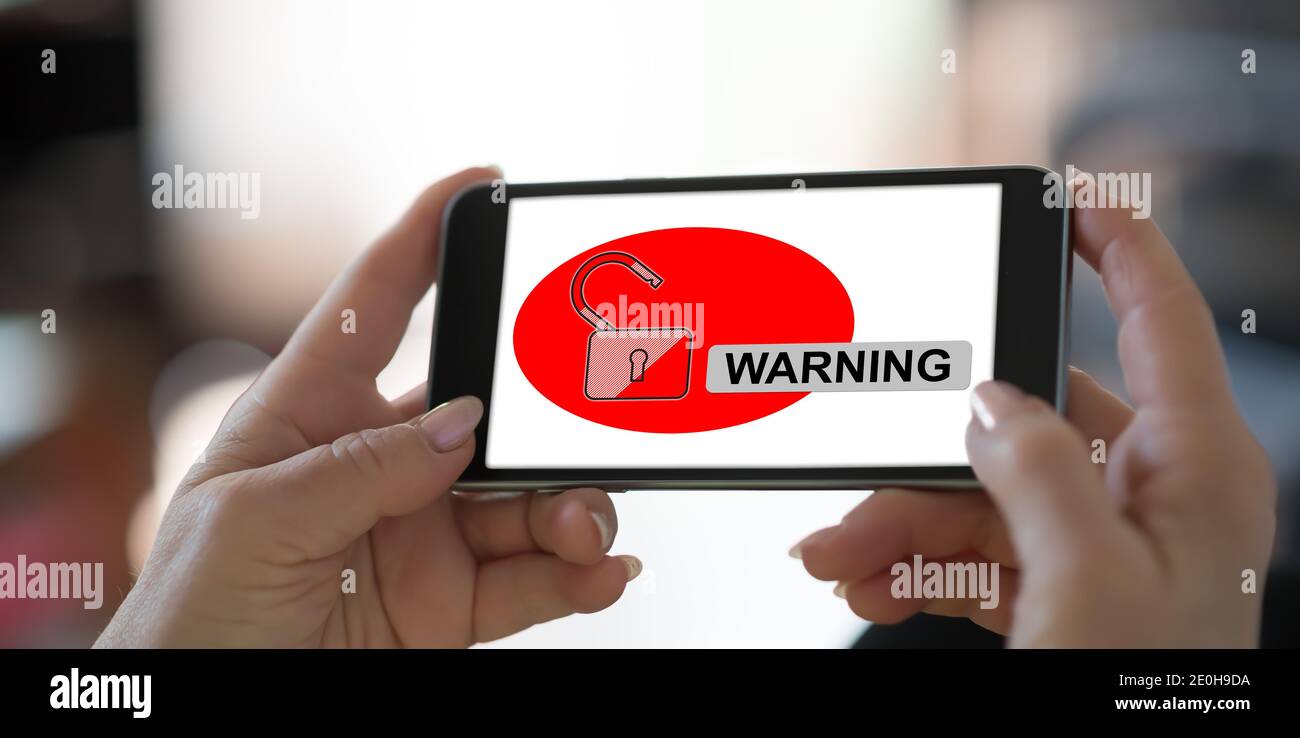 Hand holding a smartphone with warning concept Stock Photo - Alamy