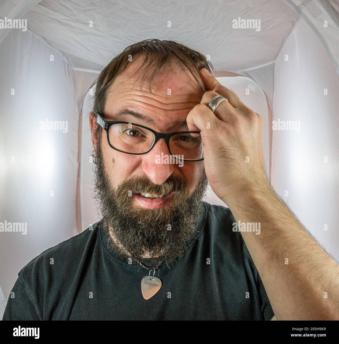 A bearded horrified looking man with black glasses Stock Photo - Alamy