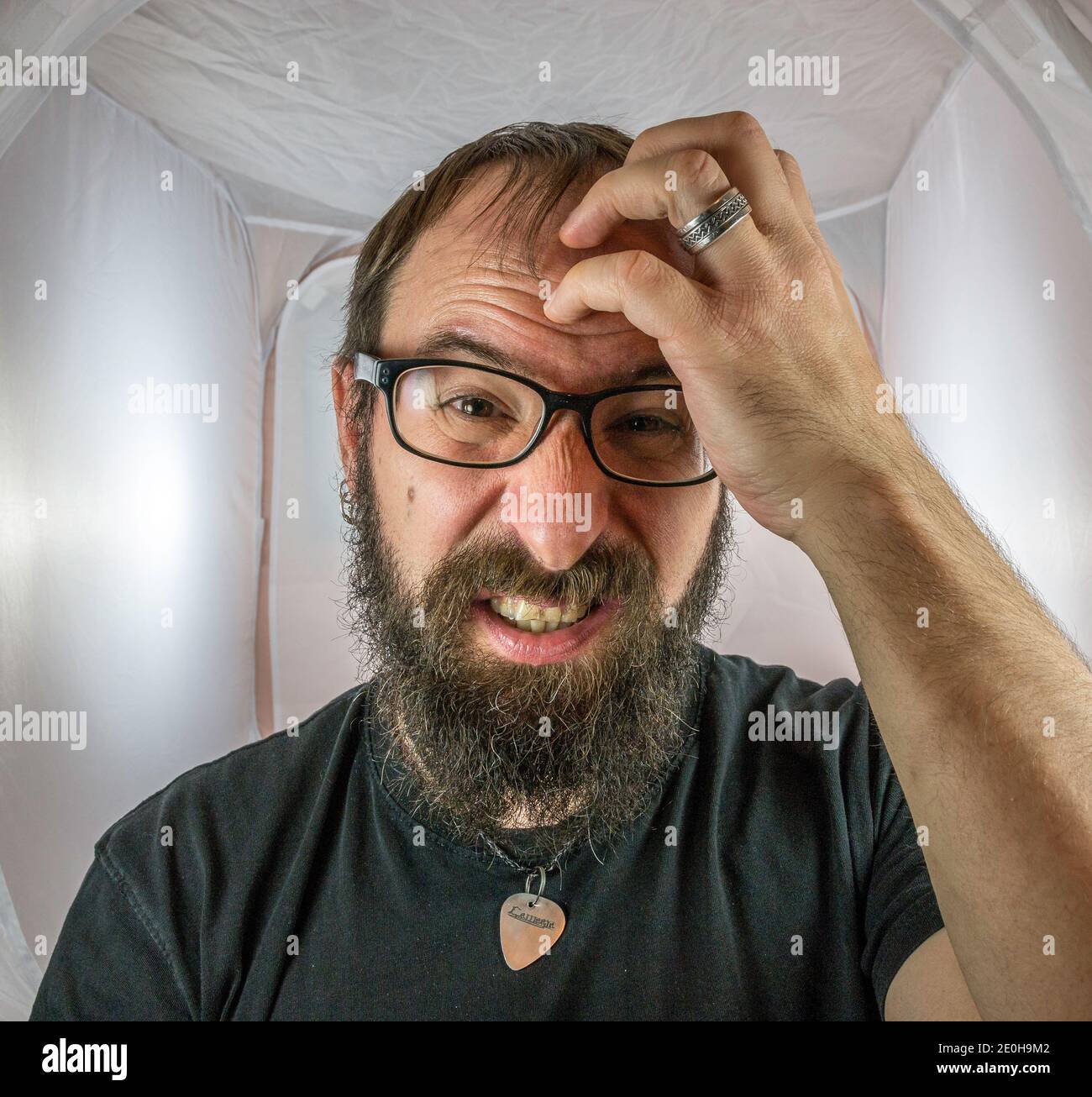 A bearded horrified looking man with black glasses Stock Photo - Alamy
