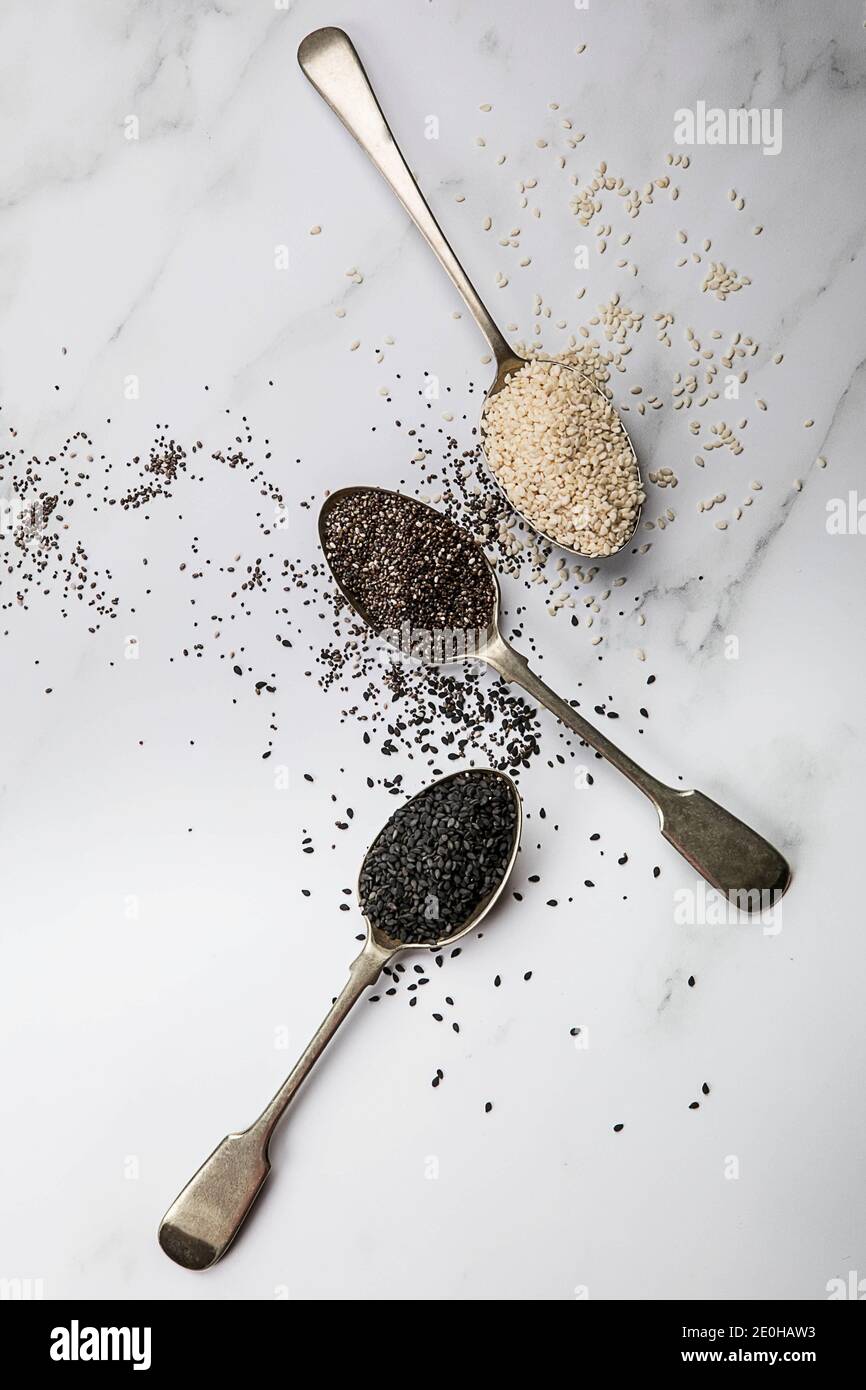 Three spoons of different coloured seeds Stock Photo - Alamy