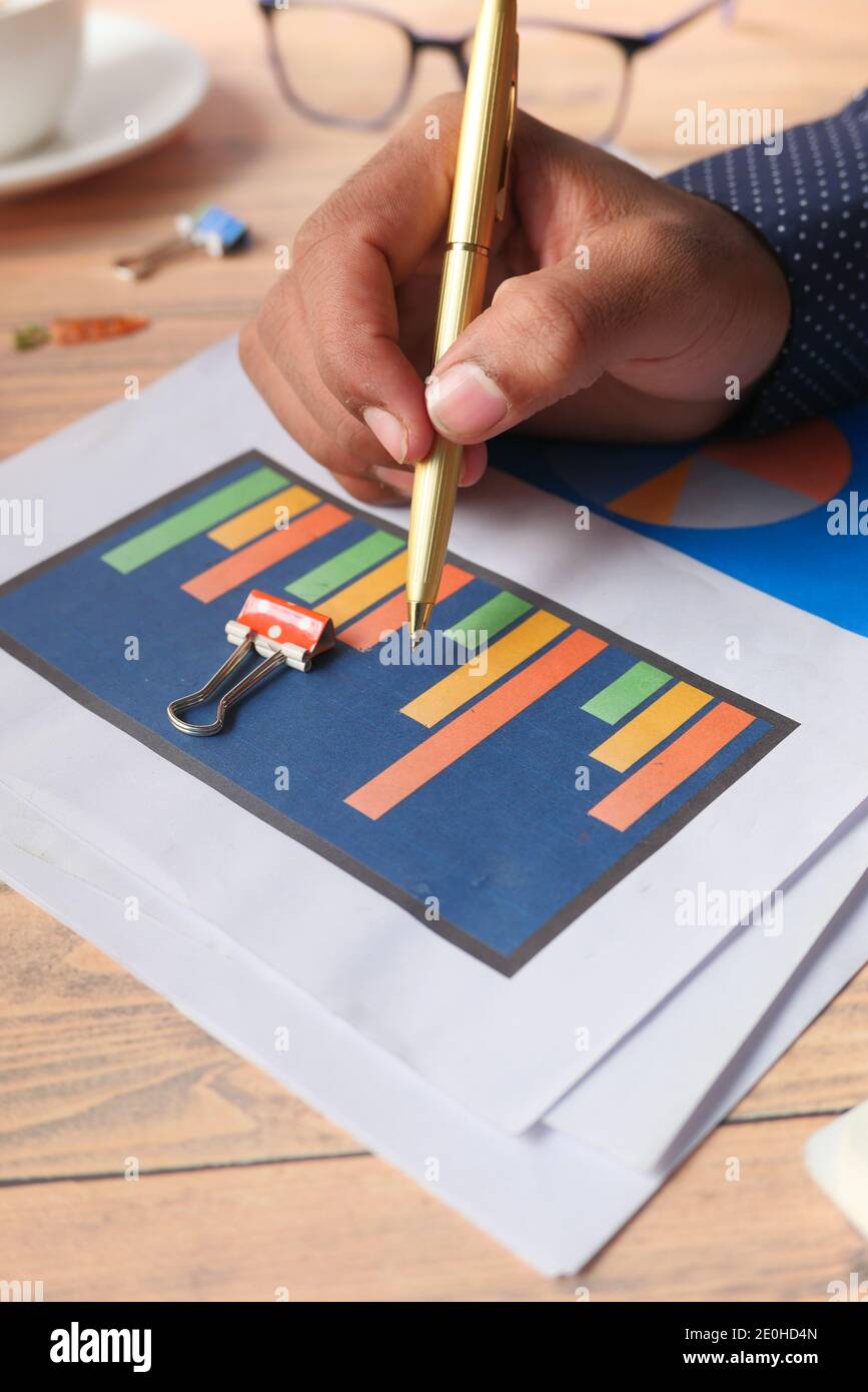 man hand with pen analyzing bar chart on paper Stock Photo - Alamy