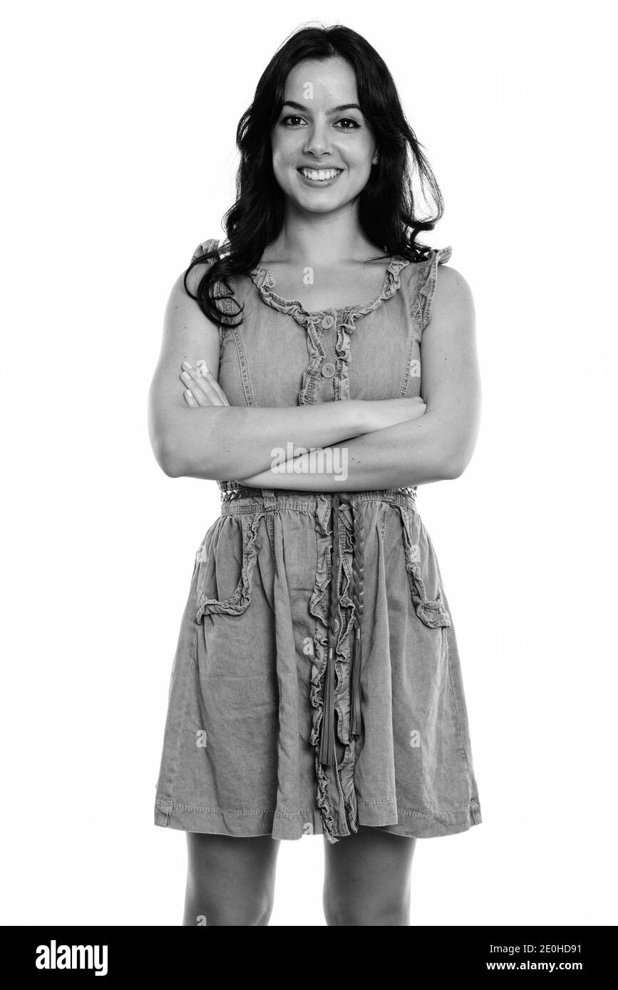 Studio shot of young happy beautiful Spanish woman smiling with arms ...