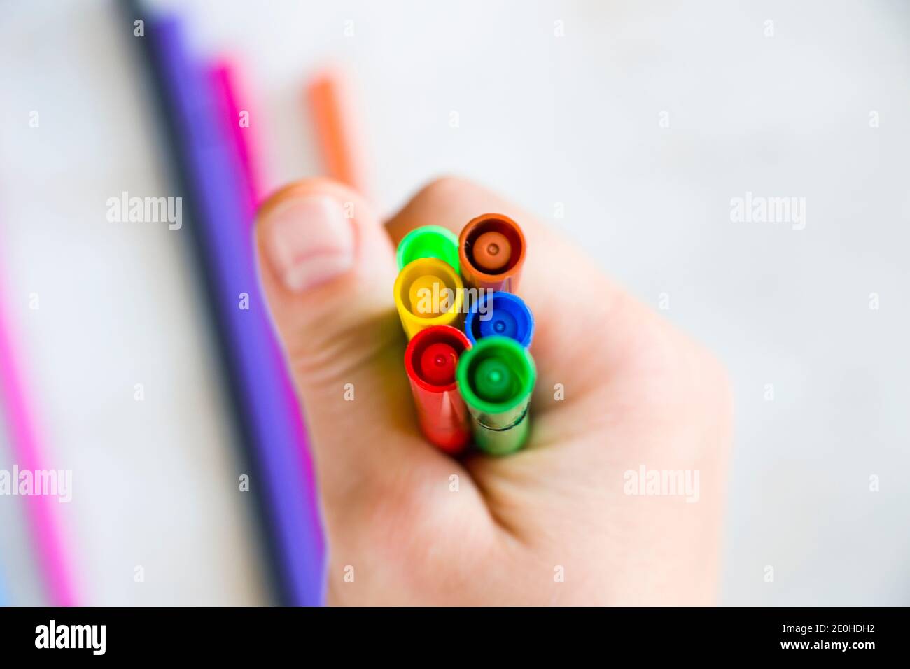 Large group of colorful drawing markers for sketching holds in hand, on ...