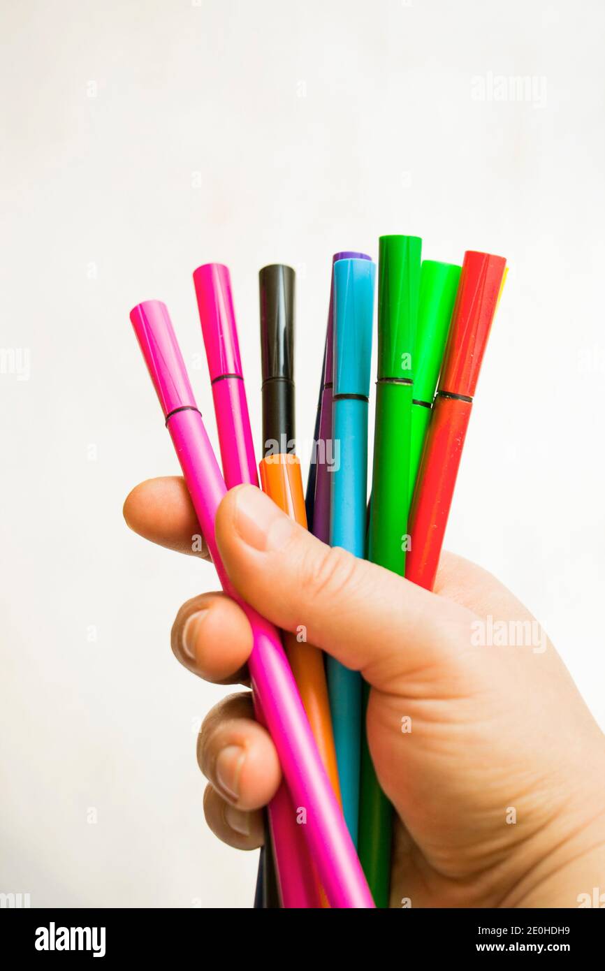 Large group of colorful drawing markers for sketching holds in hand, on ...