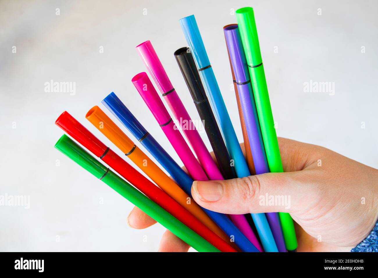 Large group of colorful drawing markers for sketching holds in hand, on ...