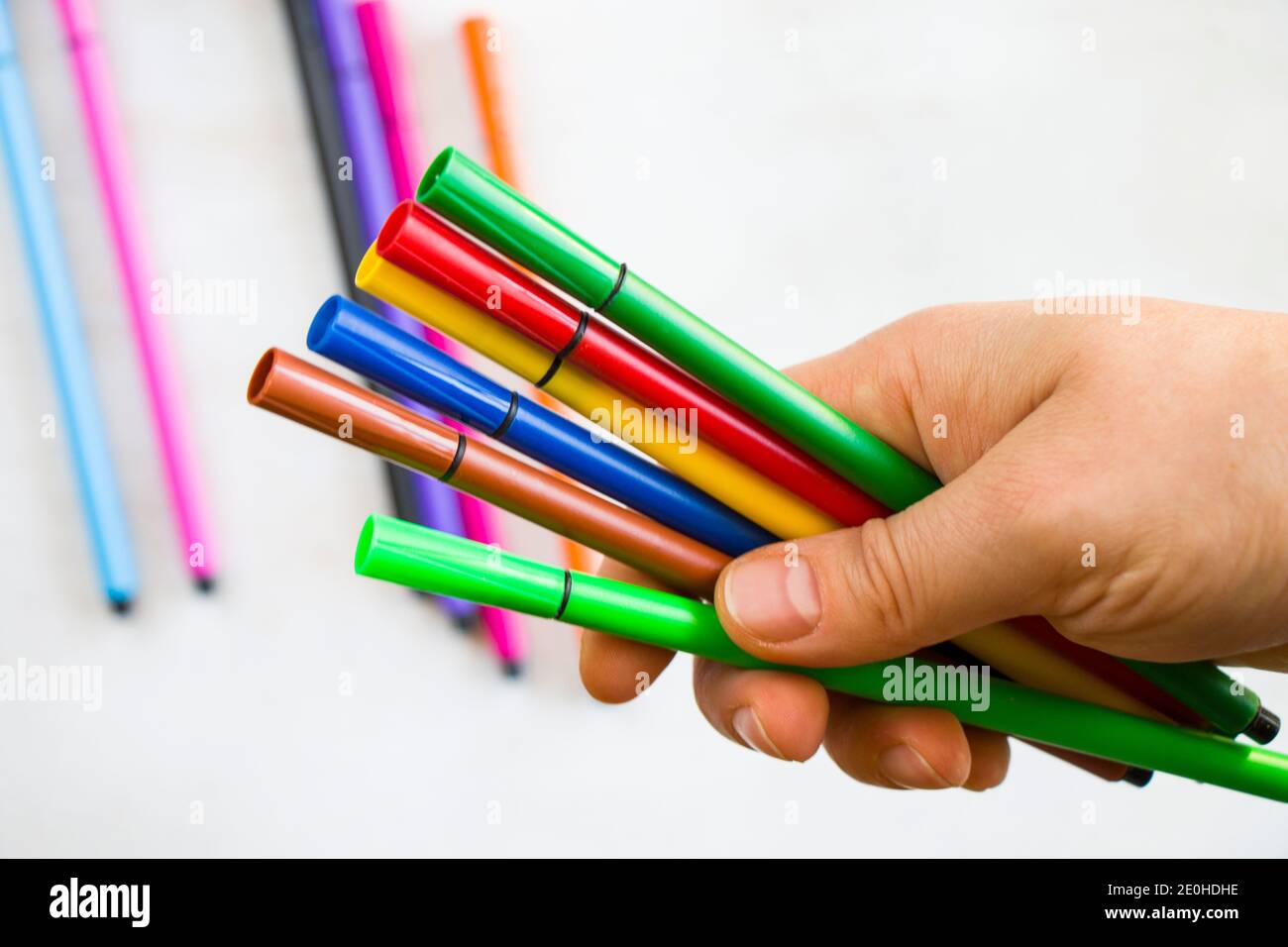 Large group of colorful drawing markers for sketching holds in hand, on ...