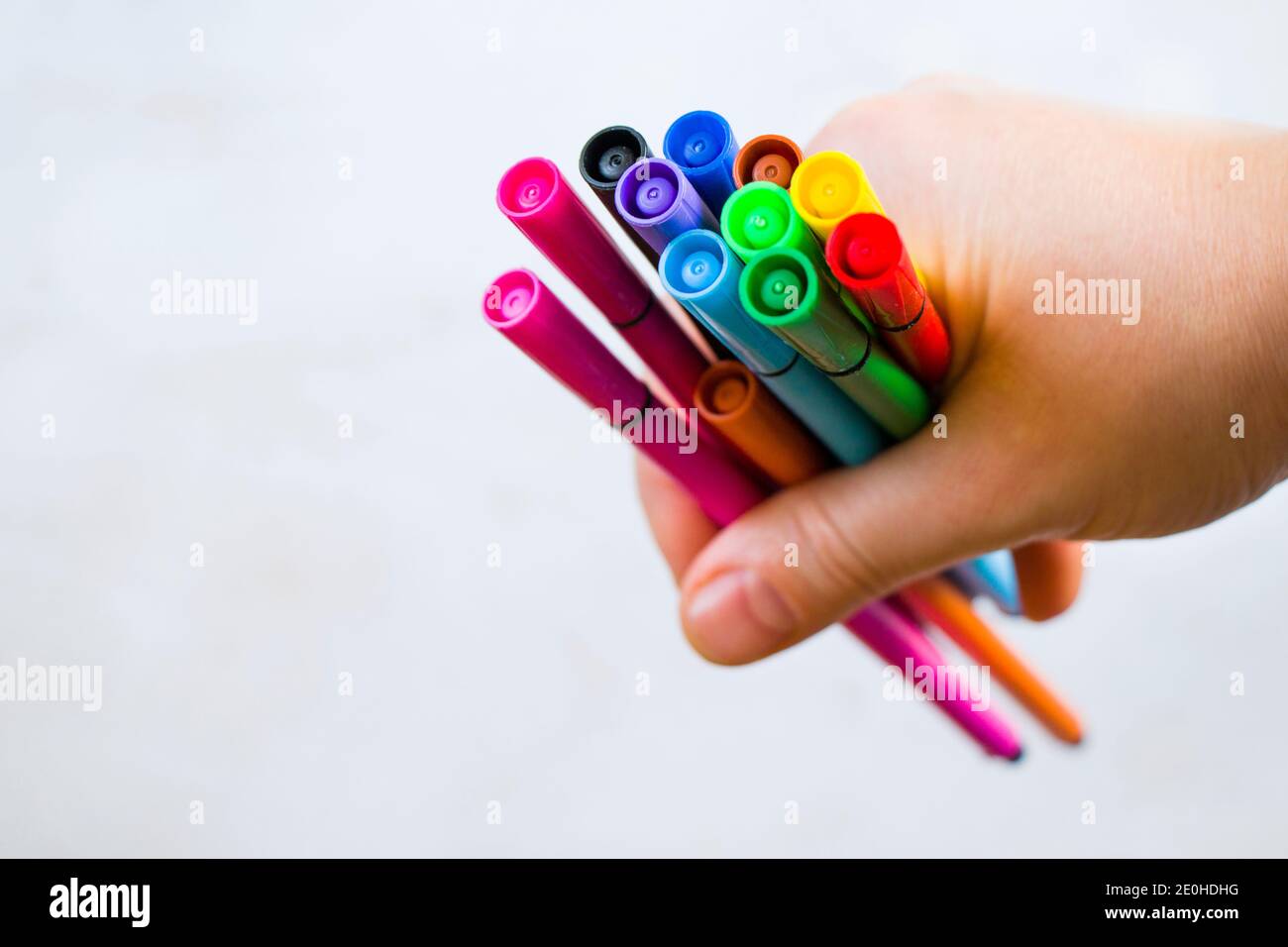 Large group of colorful drawing markers for sketching holds in hand, on ...