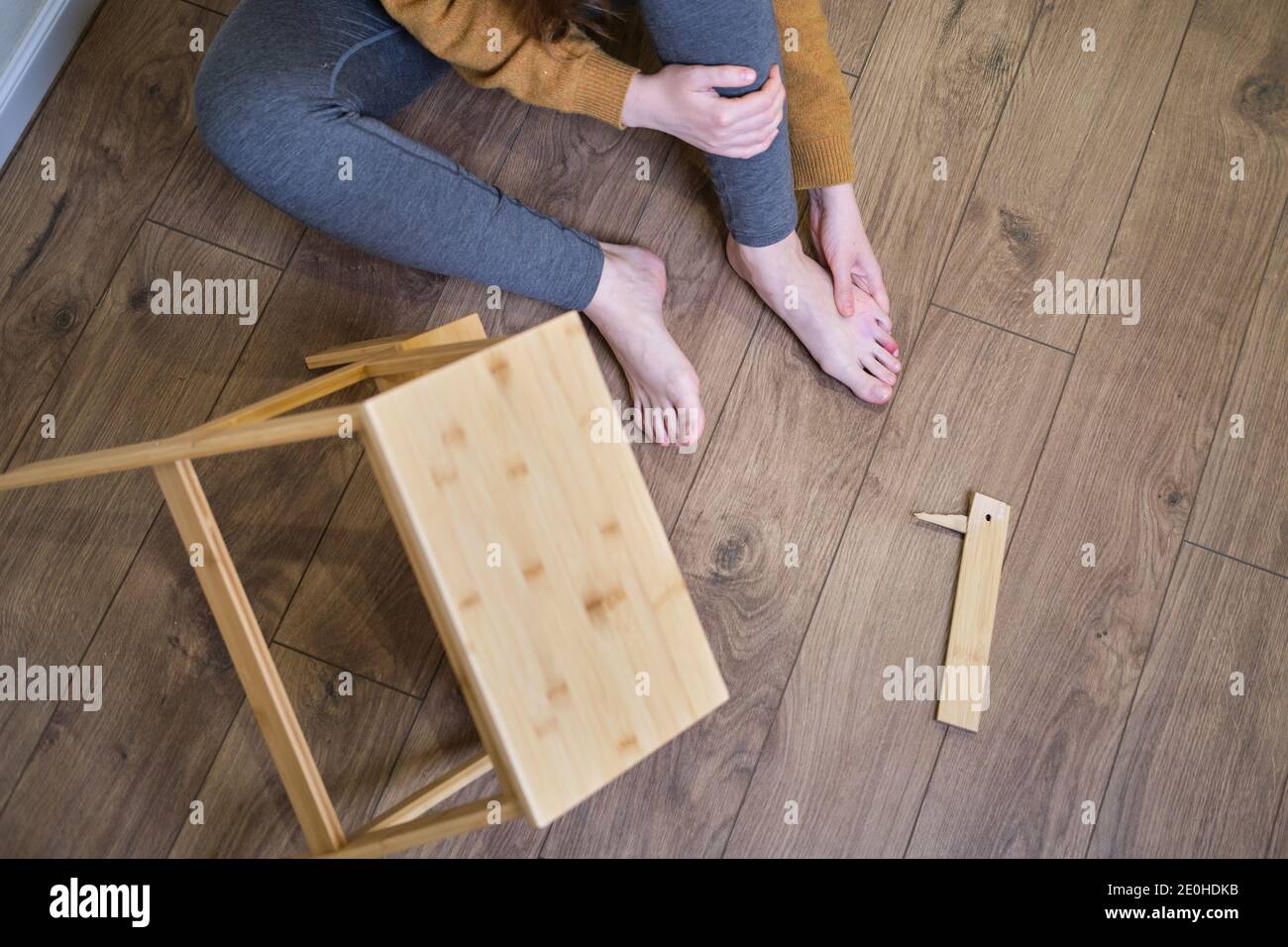 A man holds on to his injured leg after falling from a wooden ladder ...