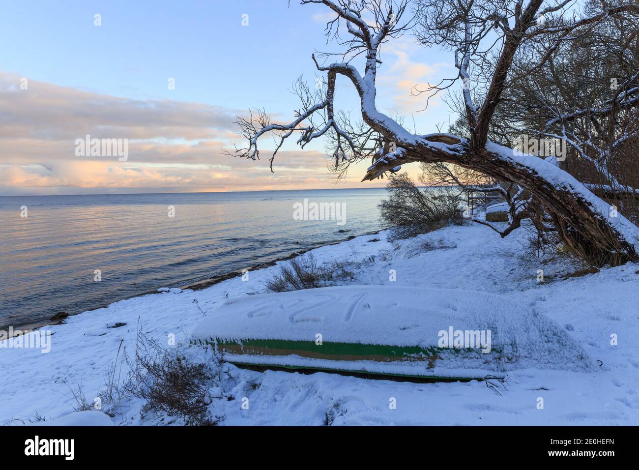Baltic Sea coast in winter, fishing boat with an inscription on the ...